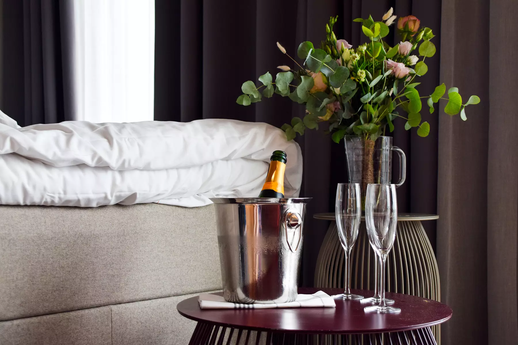 Romantische setting in de slaapkamer met champagne en verse bloemen in een hotelkamer