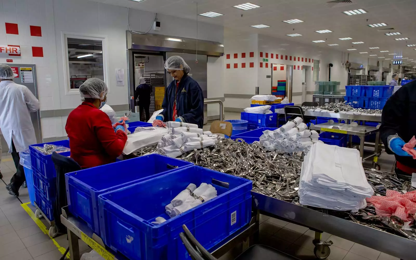 Bestek wordt gepolijst en gescheiden om trays voor te bereiden op aankomende vluchten.