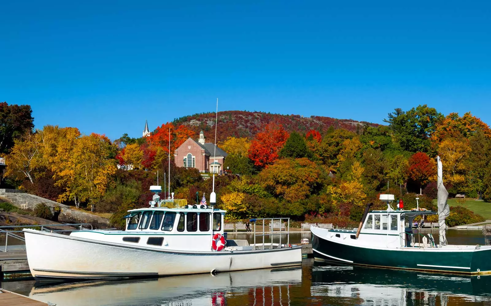 Barcos de langosta en Camden, puerto de Maine con follaje de otoño