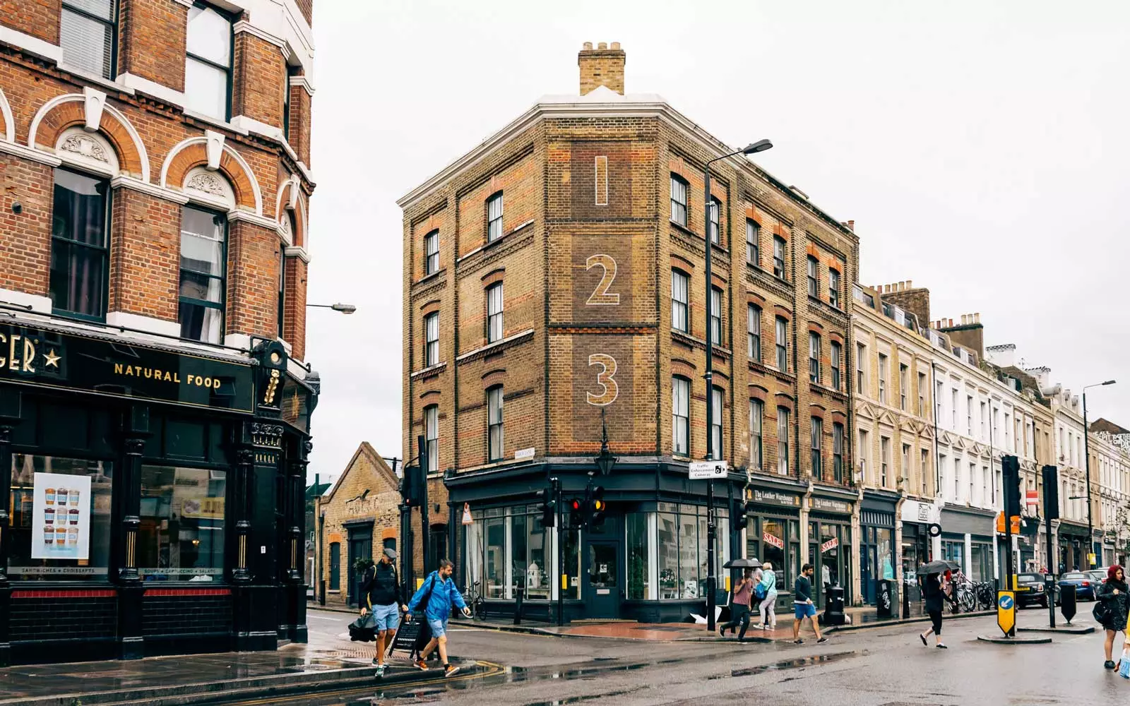 Yağışlı bir gündə Bethnal Green Road keçən insanlar. Shoreditch-də, Brick Lane Marketin yaxınlığında yerləşir.