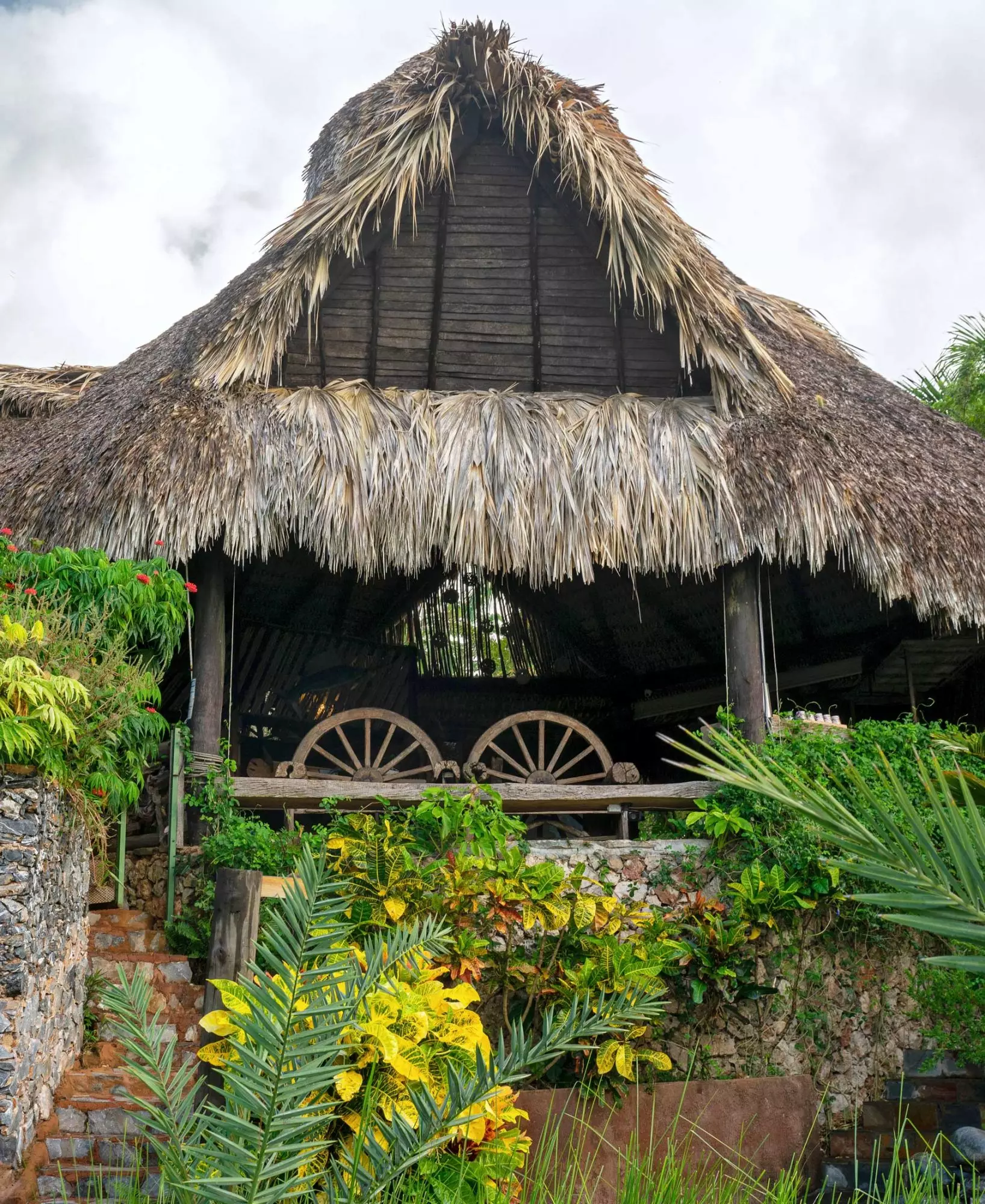 Buitenkant van een rietgedekte villa in een weelderig landschap in Casa El Paraiso, in de Dominicaanse Republiek