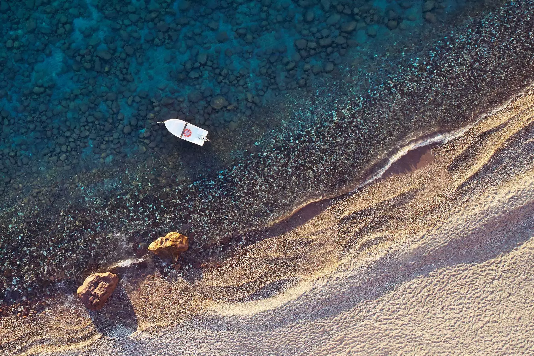 Loftopklärung vun engem klenge Boot virun der Küst vu Milos, Griicheland