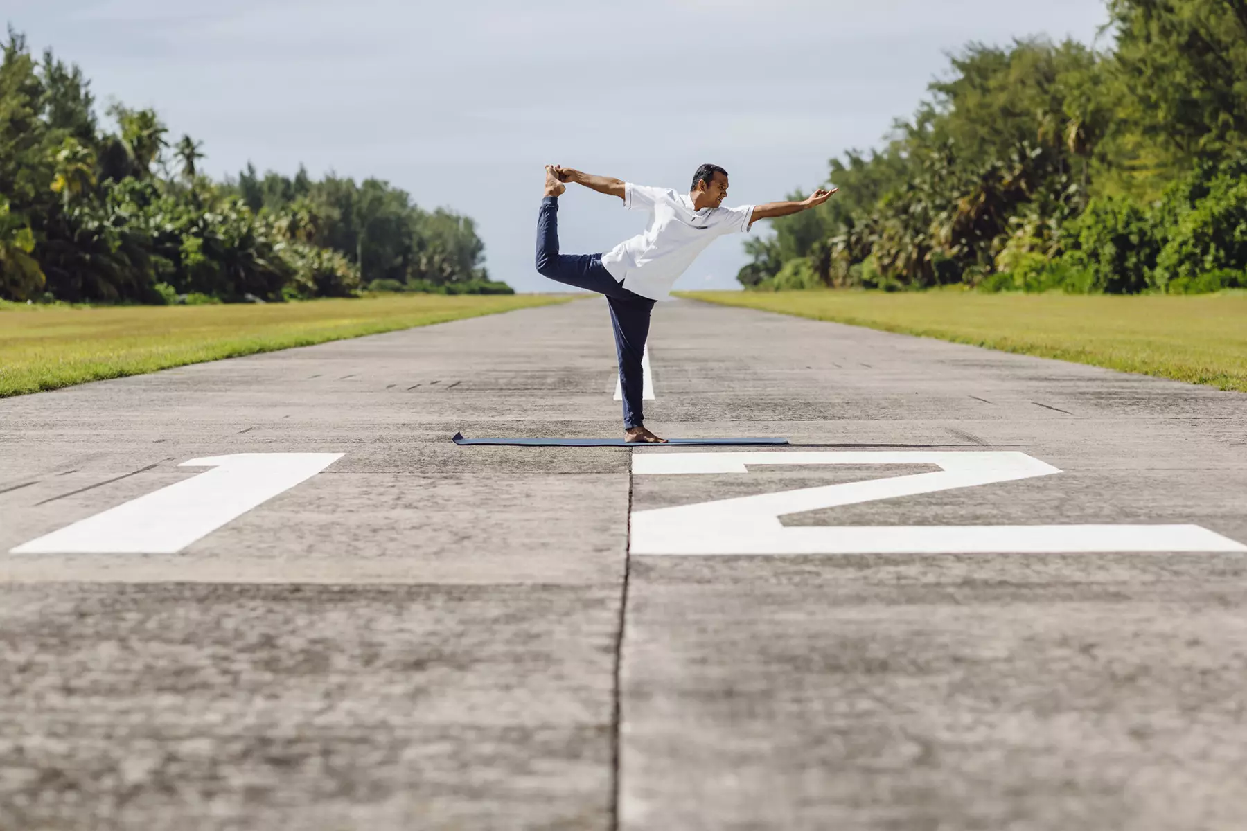 Faire du yoga sur une piste au Four Season Seychelles à Desroches Island