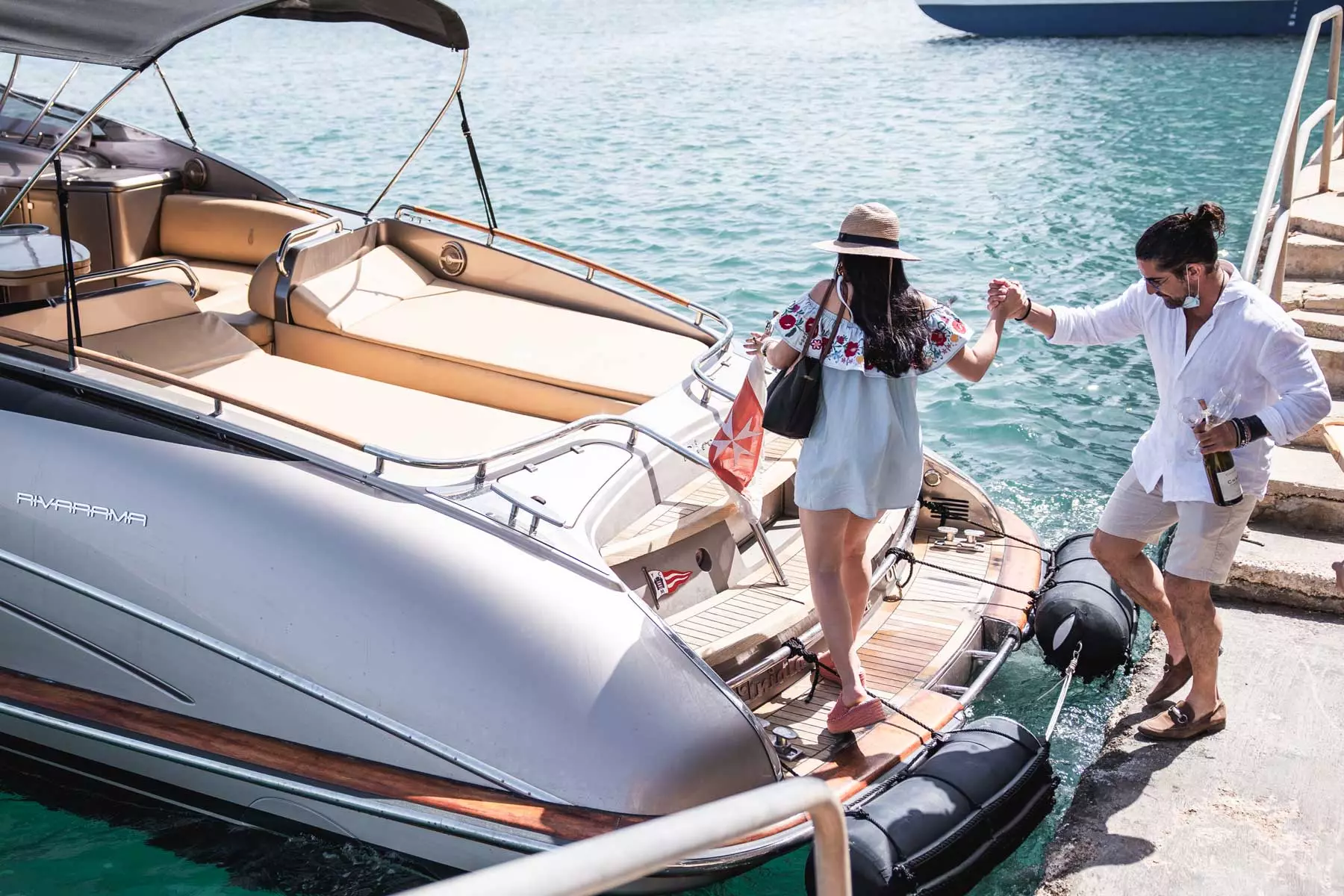 Ein Mann hilft einer Frau auf einer Yacht in Malta