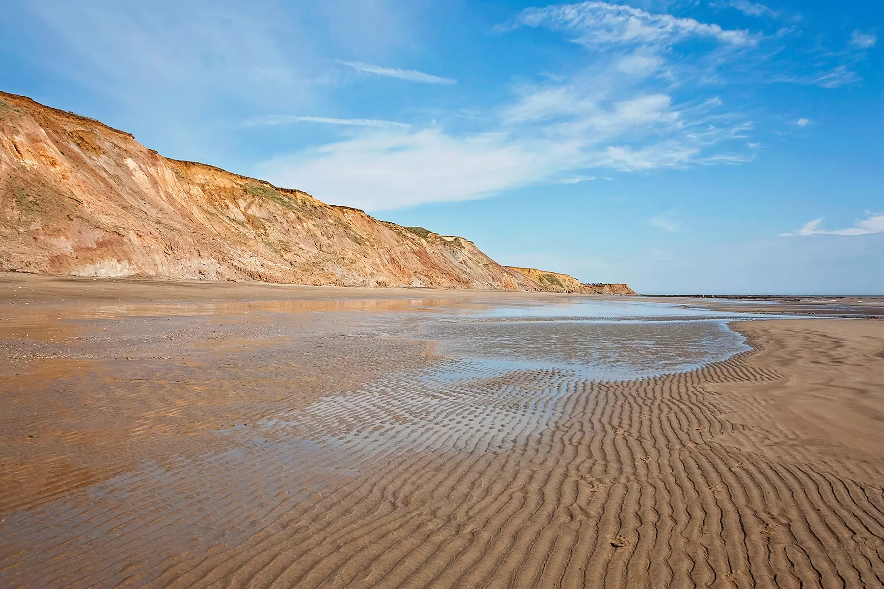 Modelli e riflessi nella sabbia a Compton Bay nell'Isola di Wight